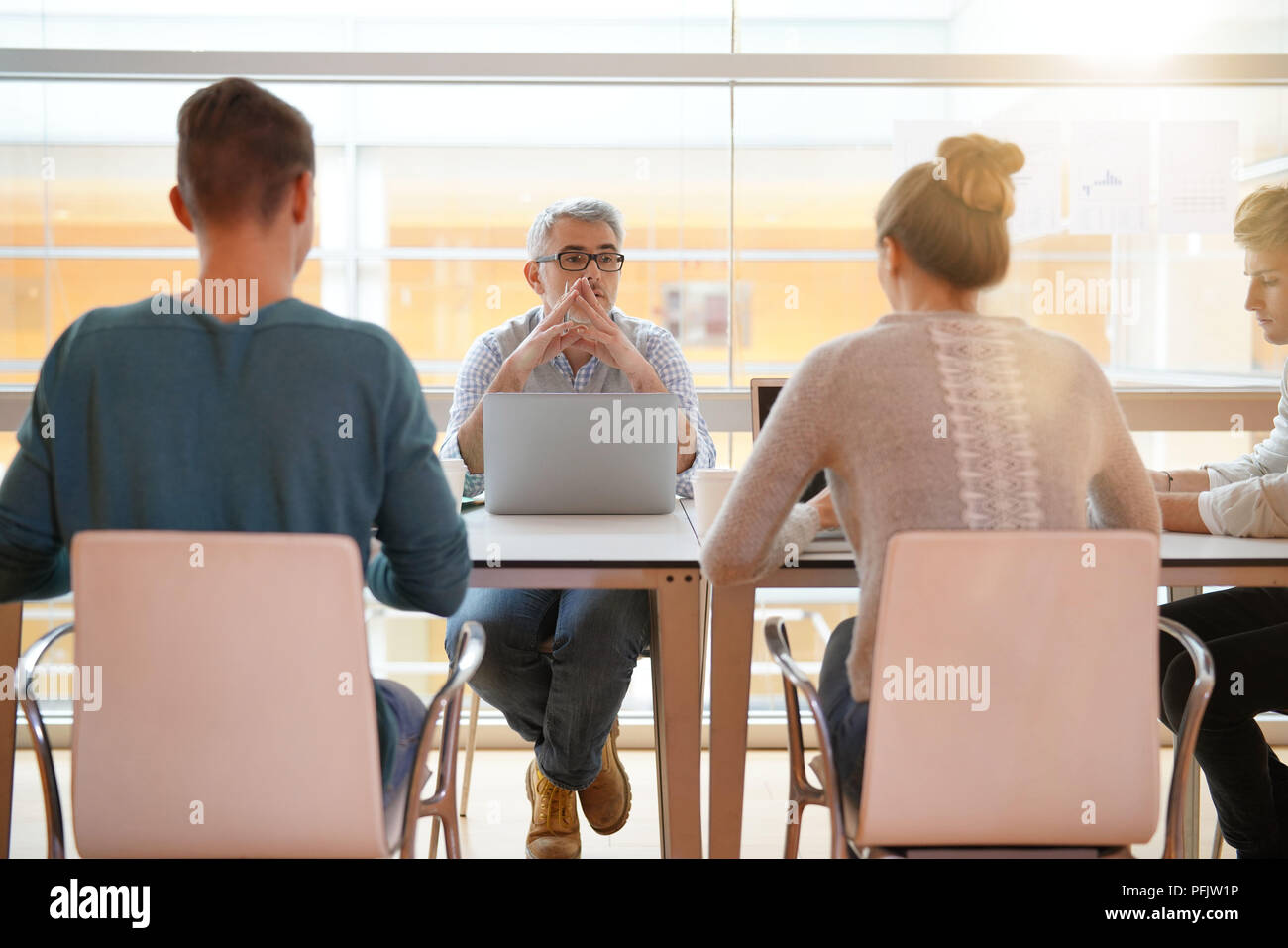 Teacher meeting around table with students Stock Photo - Alamy