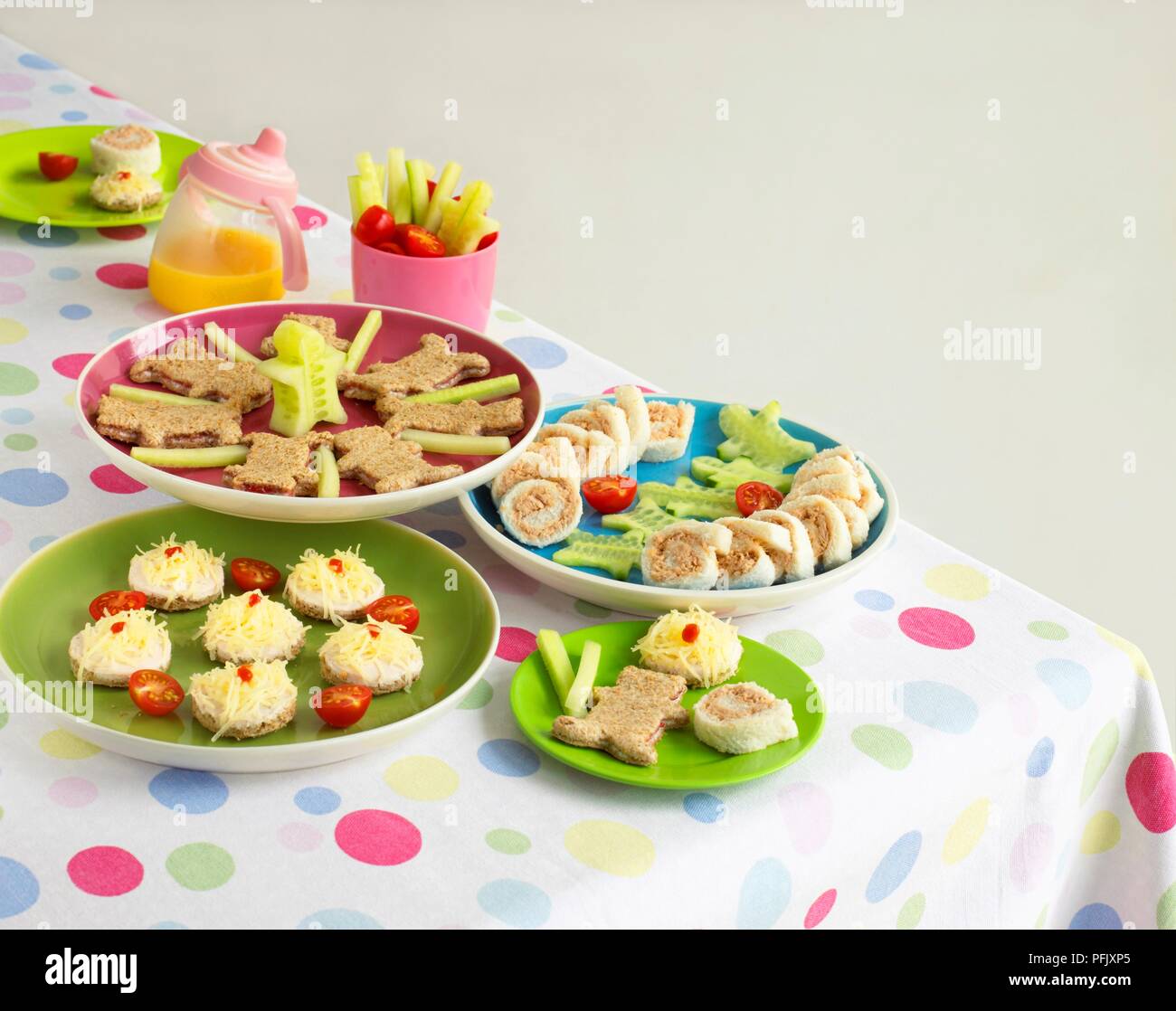 Plates of finger food on table including tuna sandwiches, cheese open ...