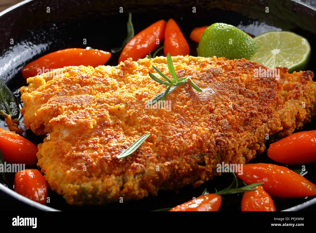 tasty fried breaded white fish steak with glazed carrots, cut into ...