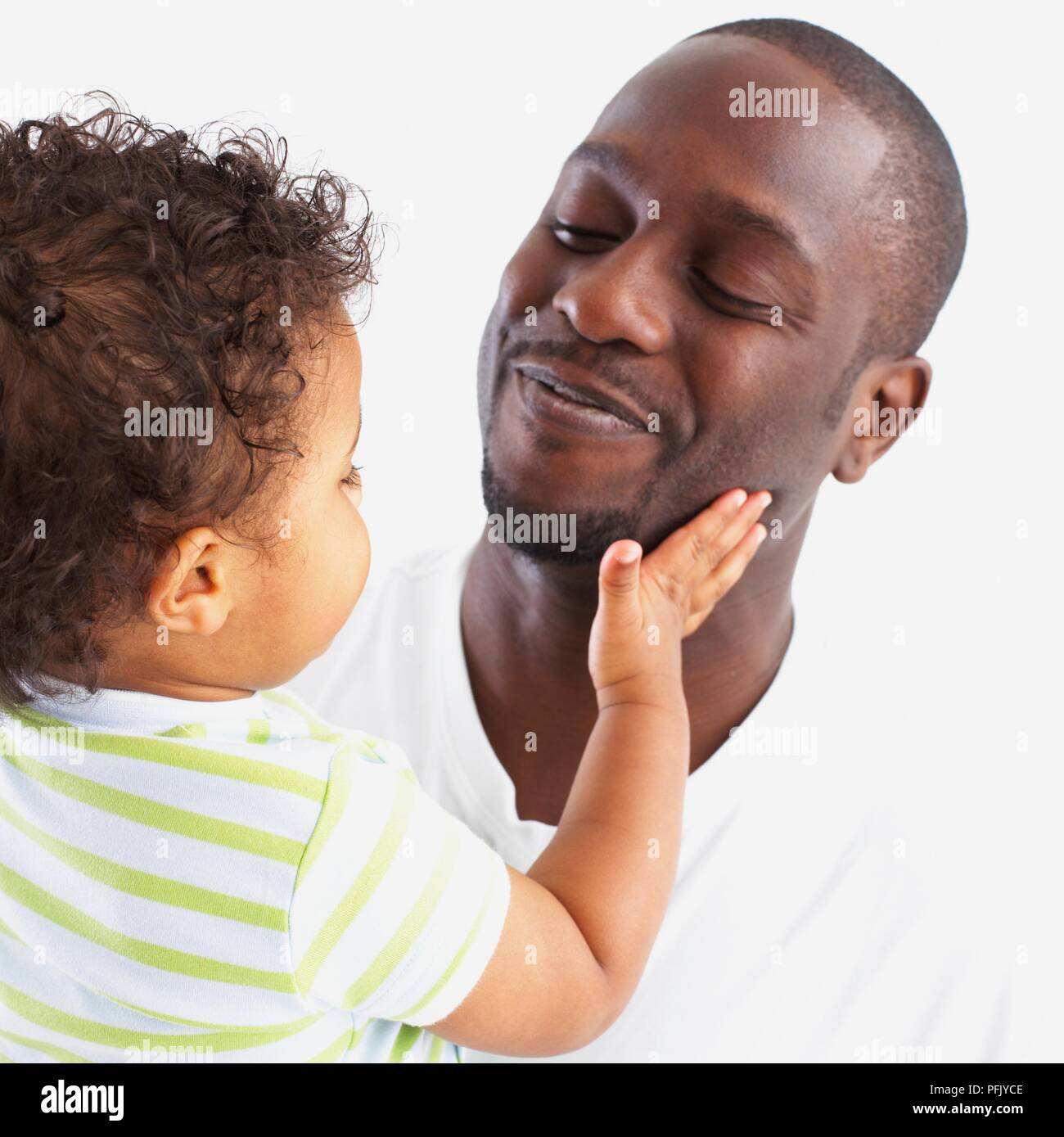 Baby boy touching man's face, close-up Stock Photo - Alamy