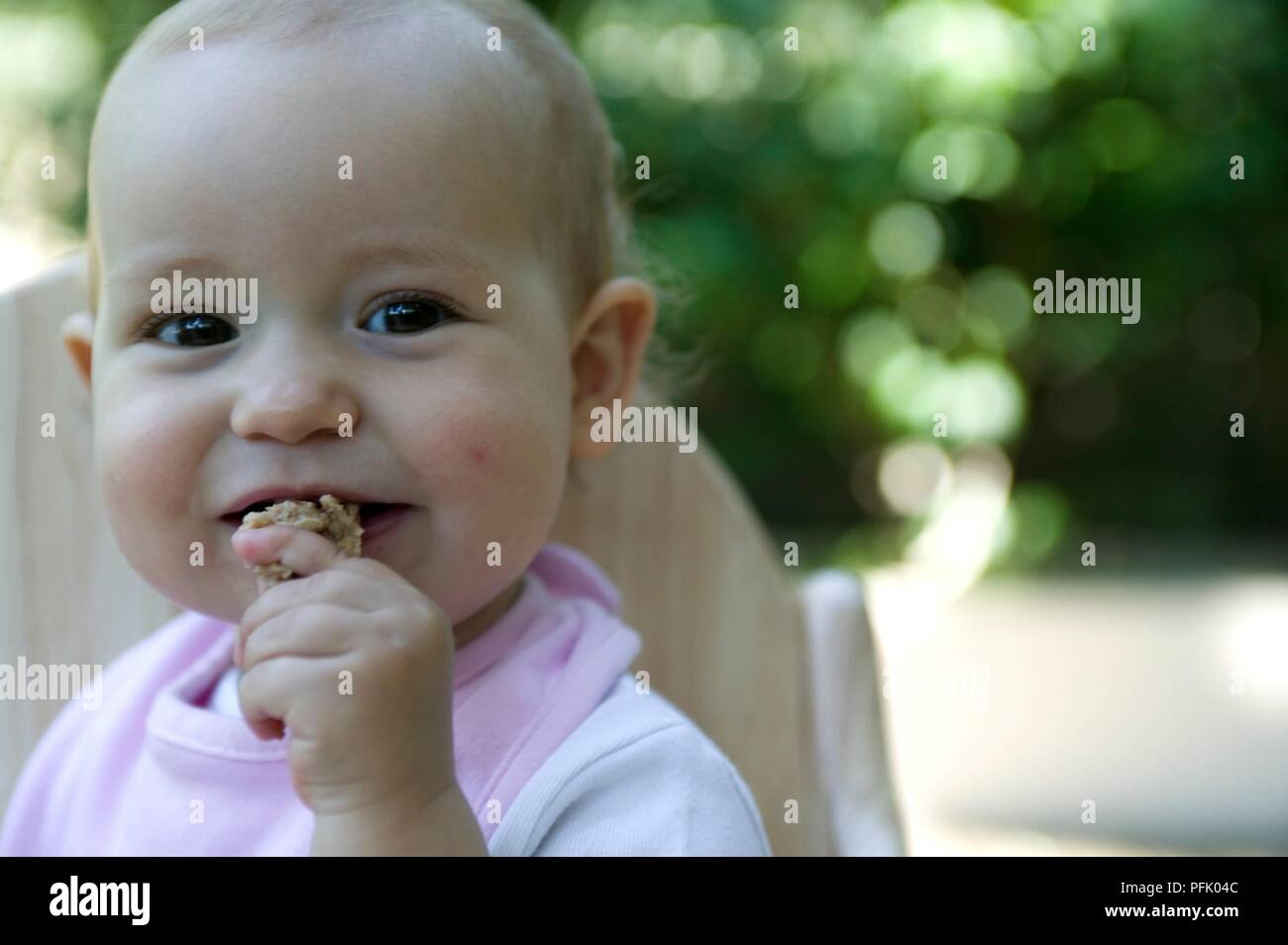 Baby girl eating biscuit hi-res stock photography and images - Alamy