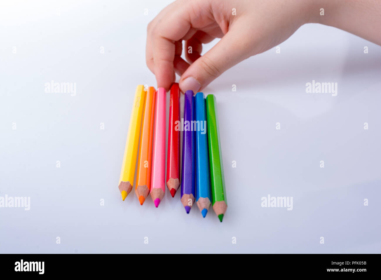 Hand holding color Pencils placed on a white background Stock Photo - Alamy
