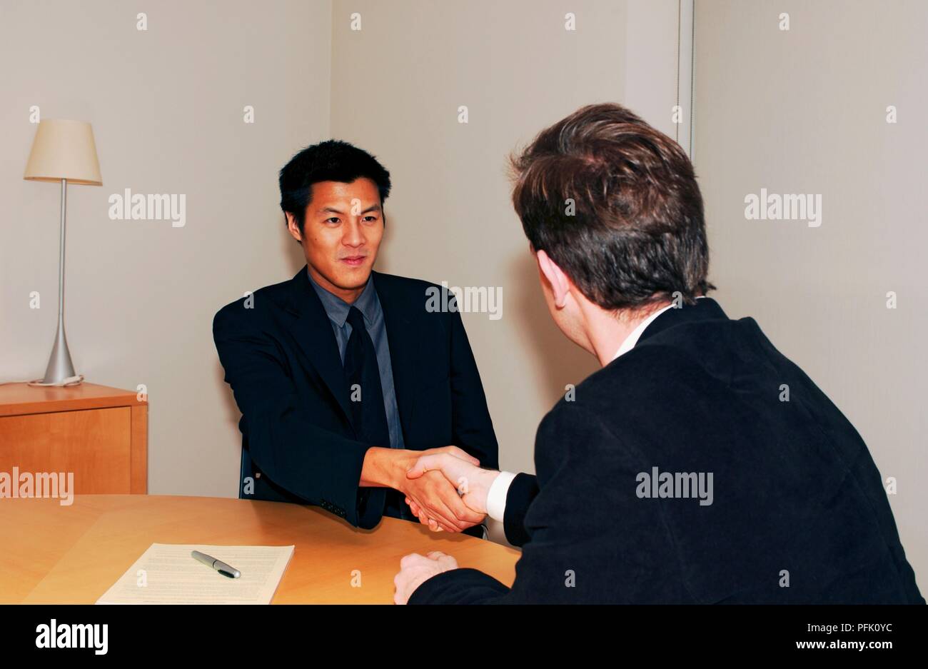 Two men sitting across the desk hi-res stock photography and images - Alamy