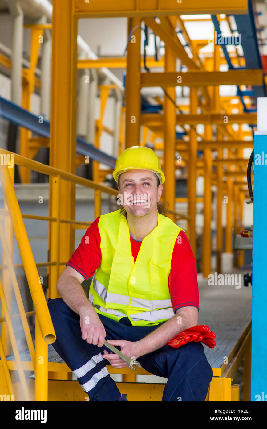 Factory worker smiling in a factory and relaxing after work Stock Photo ...