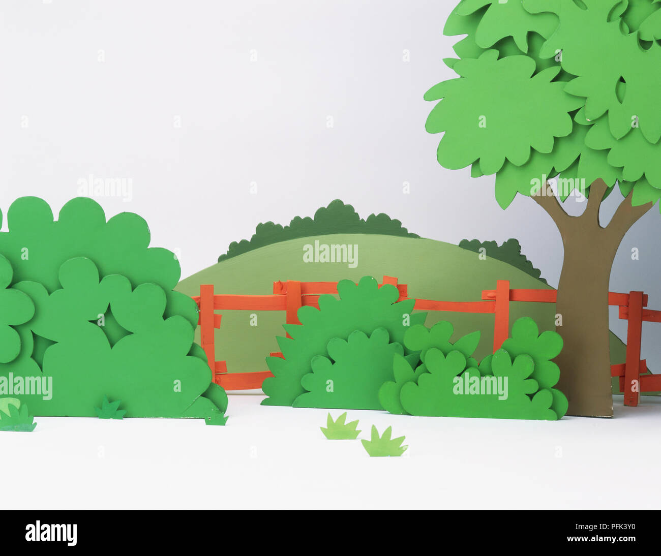 Scenery consisting of shrubs, trees, fence and hill Stock Photo - Alamy