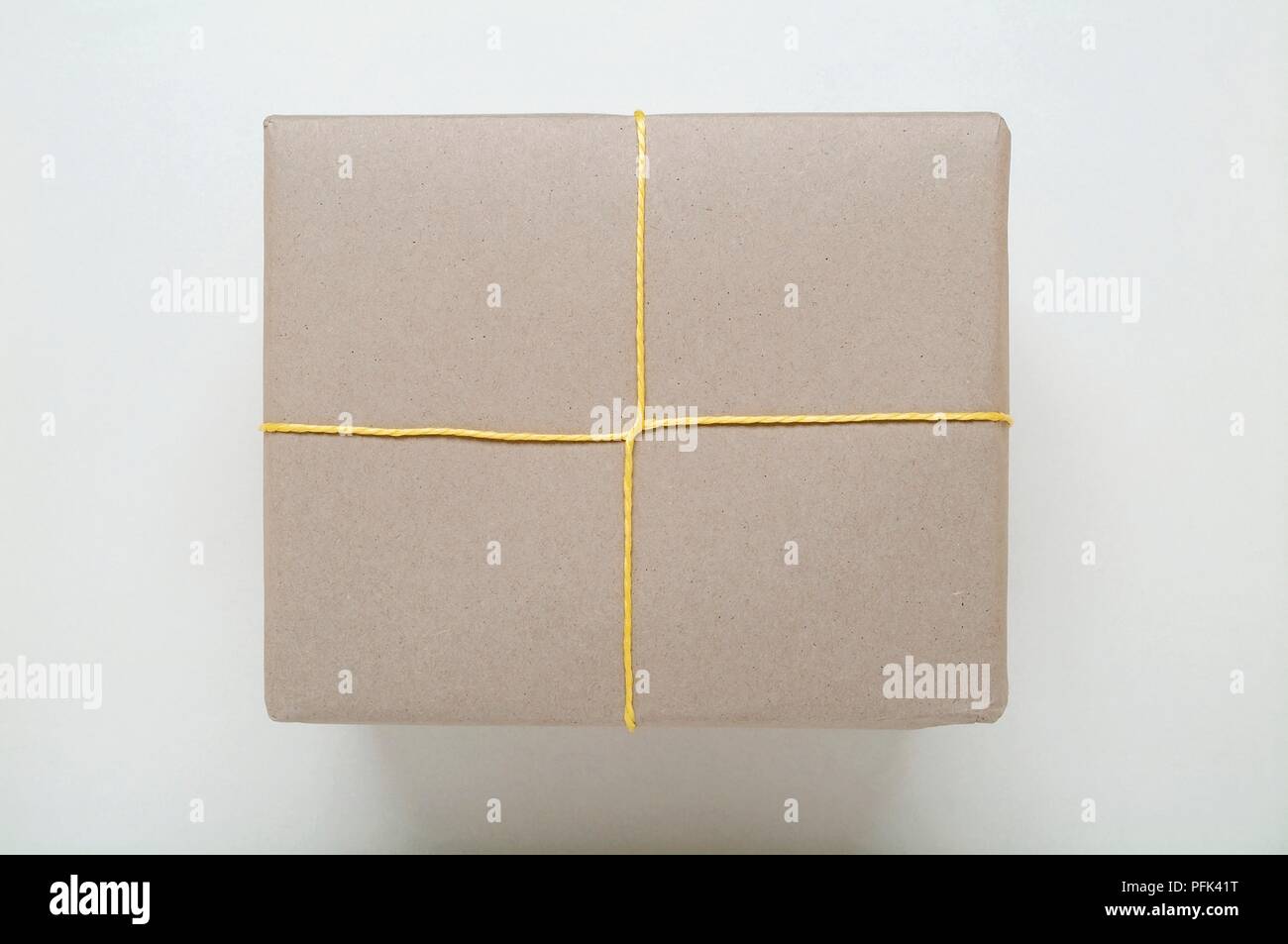 Brown parcel, tied with yellow string Stock Photo - Alamy