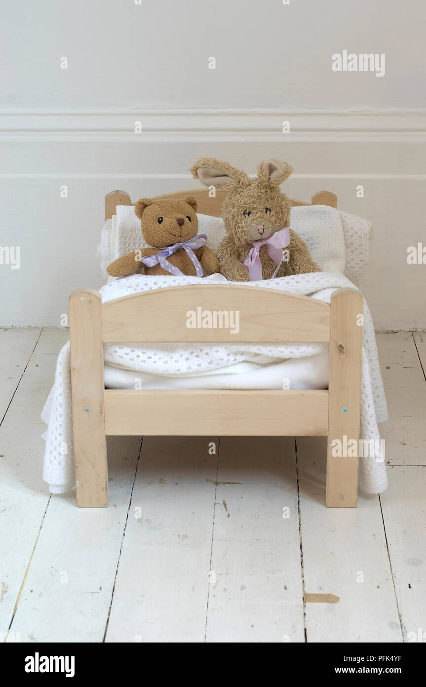 Toy rabbit and teddy bear sat in toy wooden bed Stock Photo - Alamy