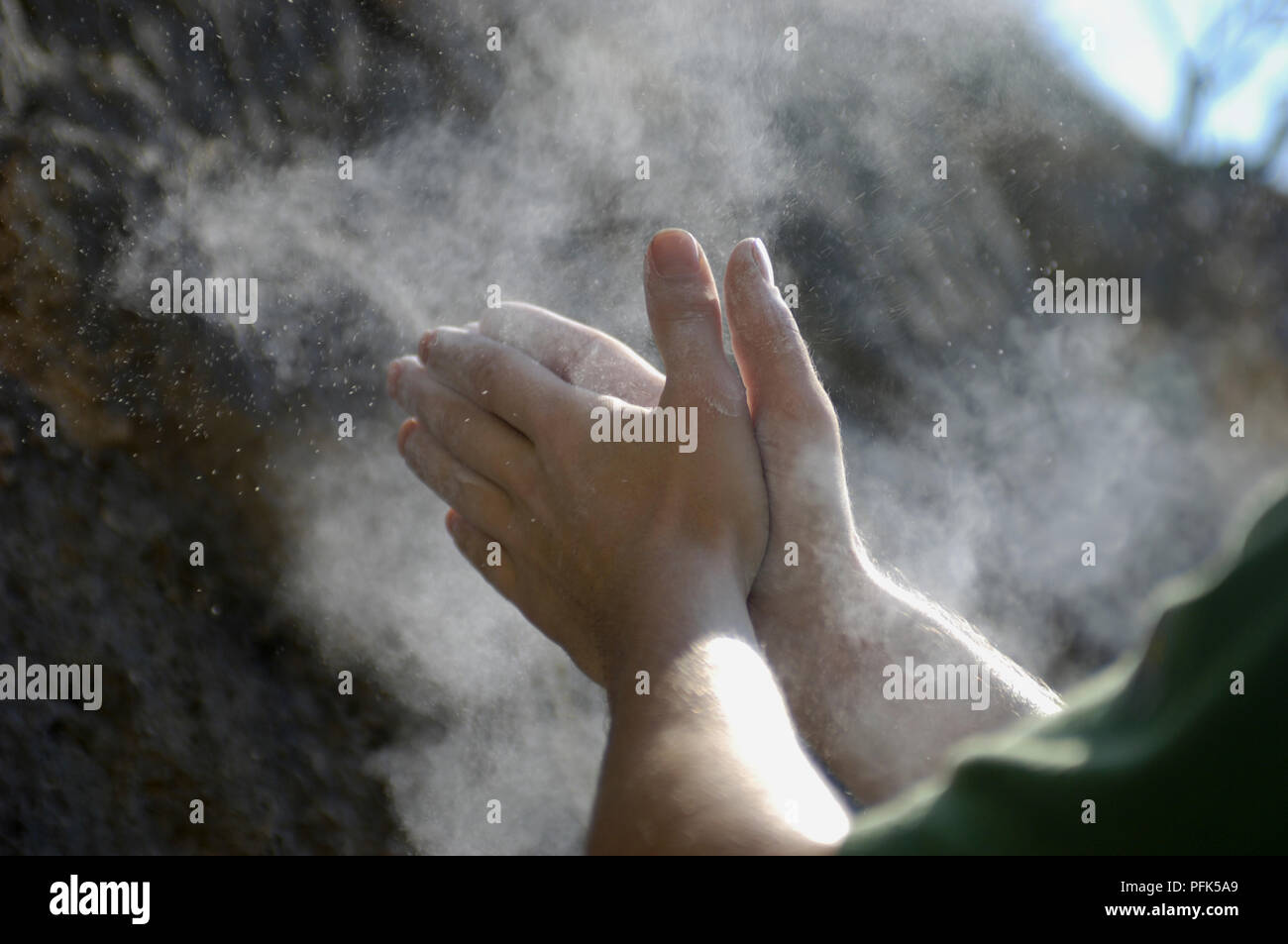 Rock climber rubbing chalk into hands Stock Photo - Alamy