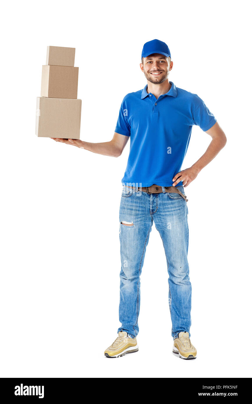 Full length portrait of smiling delivery man holding pile of cardboard ...