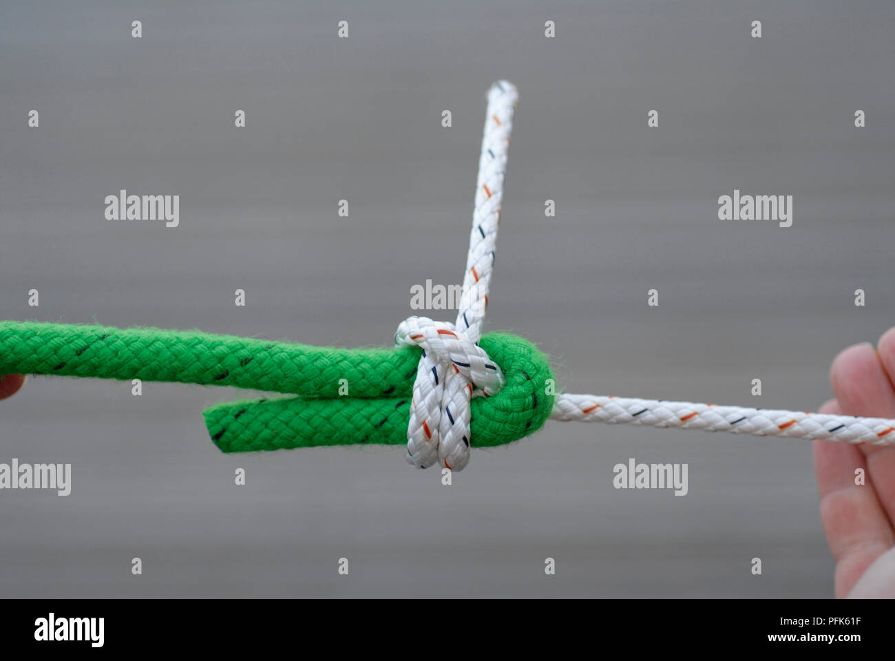 Hand tying up knot around rope Stock Photo - Alamy