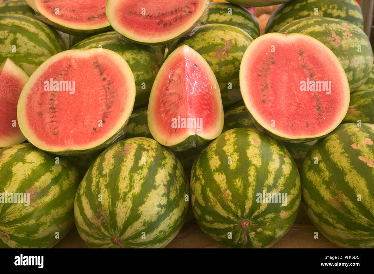 Whole, halved, and quartered, watermelons on open-air market stall ...