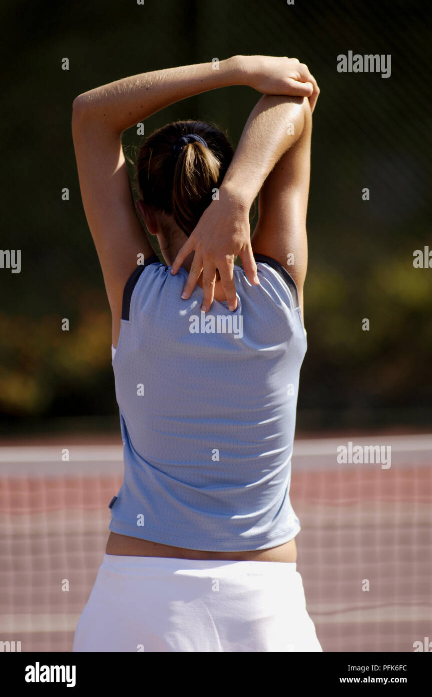 Female tennis player warming up by stretching triceps Stock Photo - Alamy