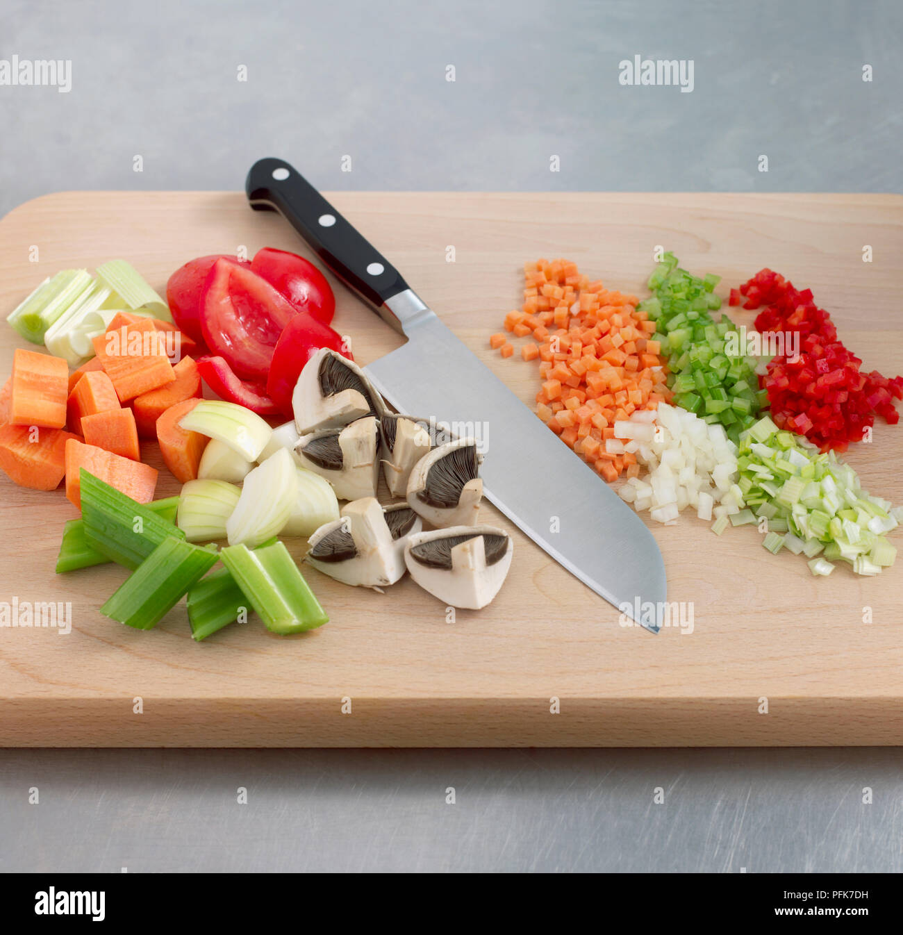 Chopped pile and diced pile of mushrooms, celery, carrots, onion and ...