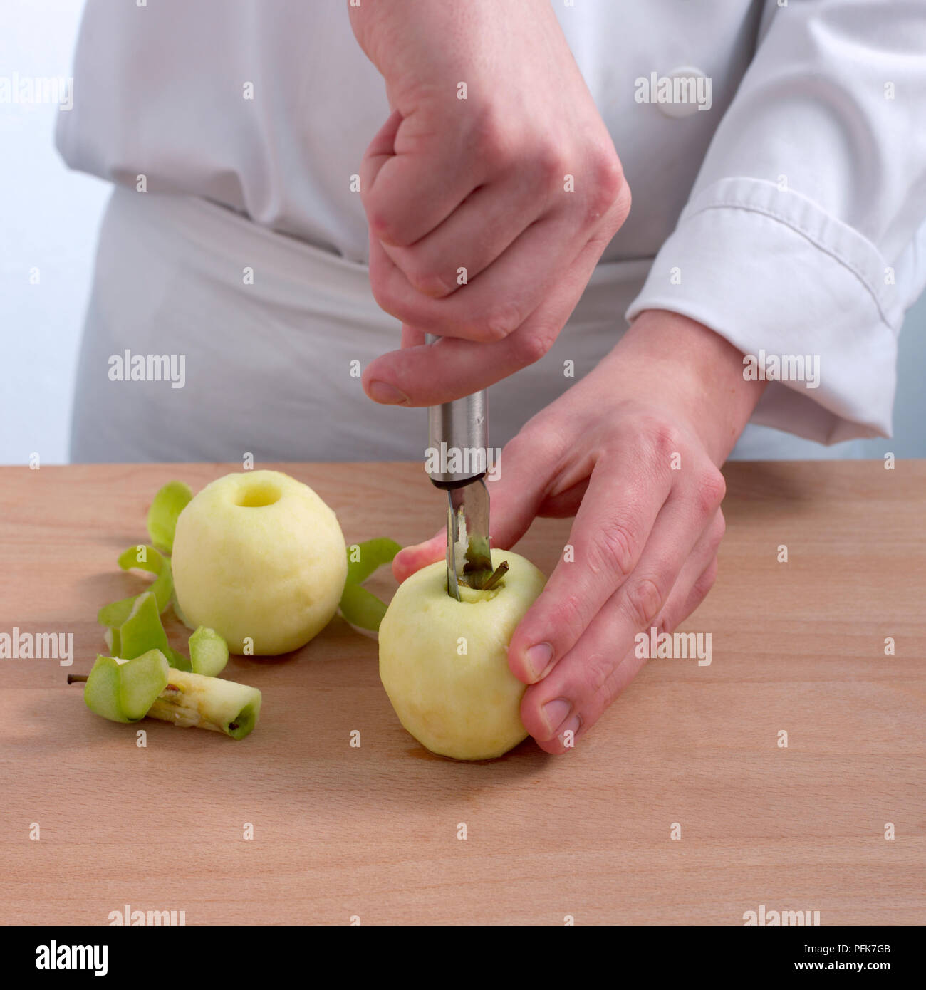 Chef coring peeled Golden Delicious apples with apple corer, close-up ...