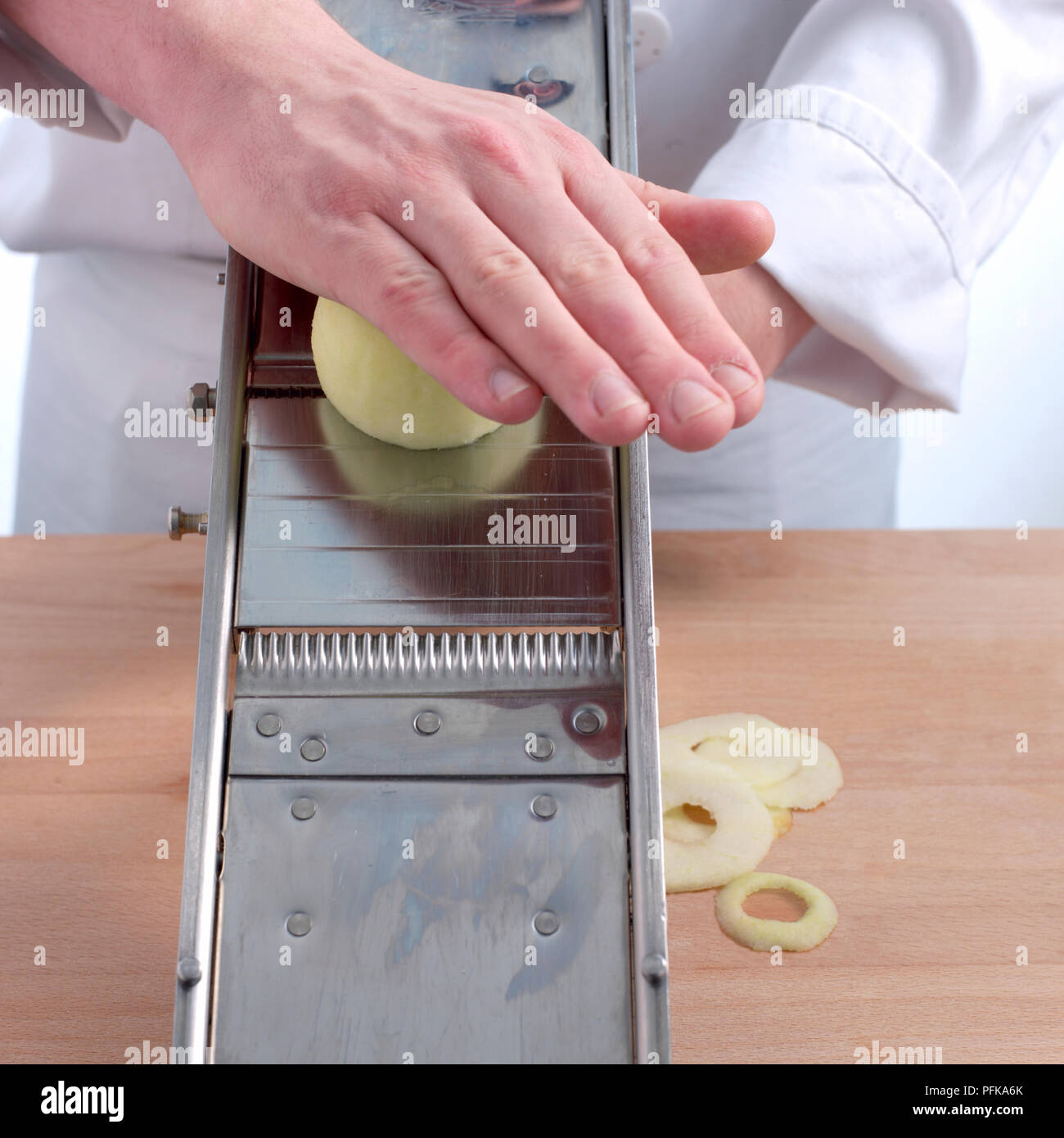 Hand slicing apple using mandolin, close-up Stock Photo - Alamy
