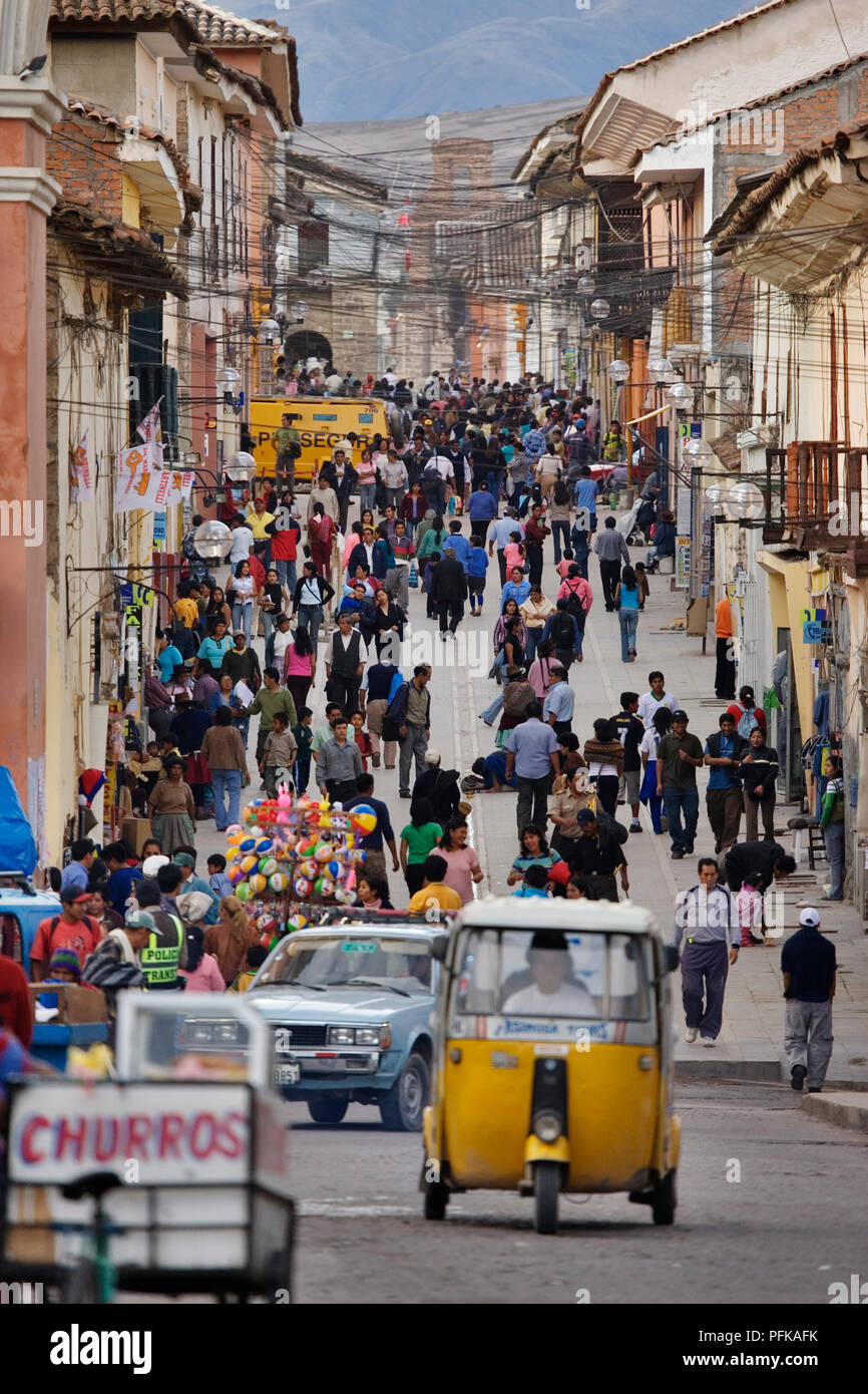 Peru, Ayacucho, street crowded with pedestrians, car and auto rickshaw ...