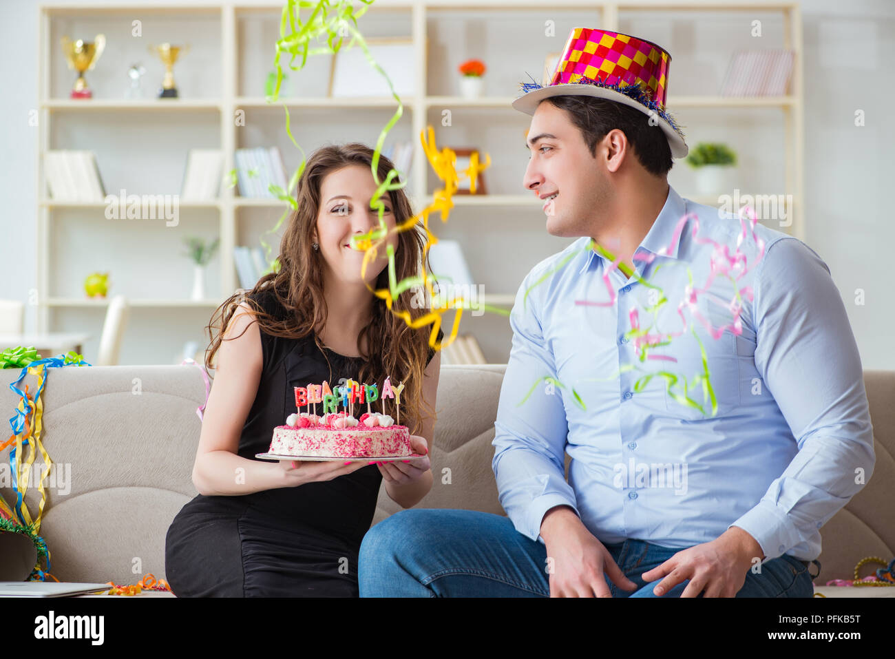 Young couple celebrating birthday with cake Stock Photo - Alamy