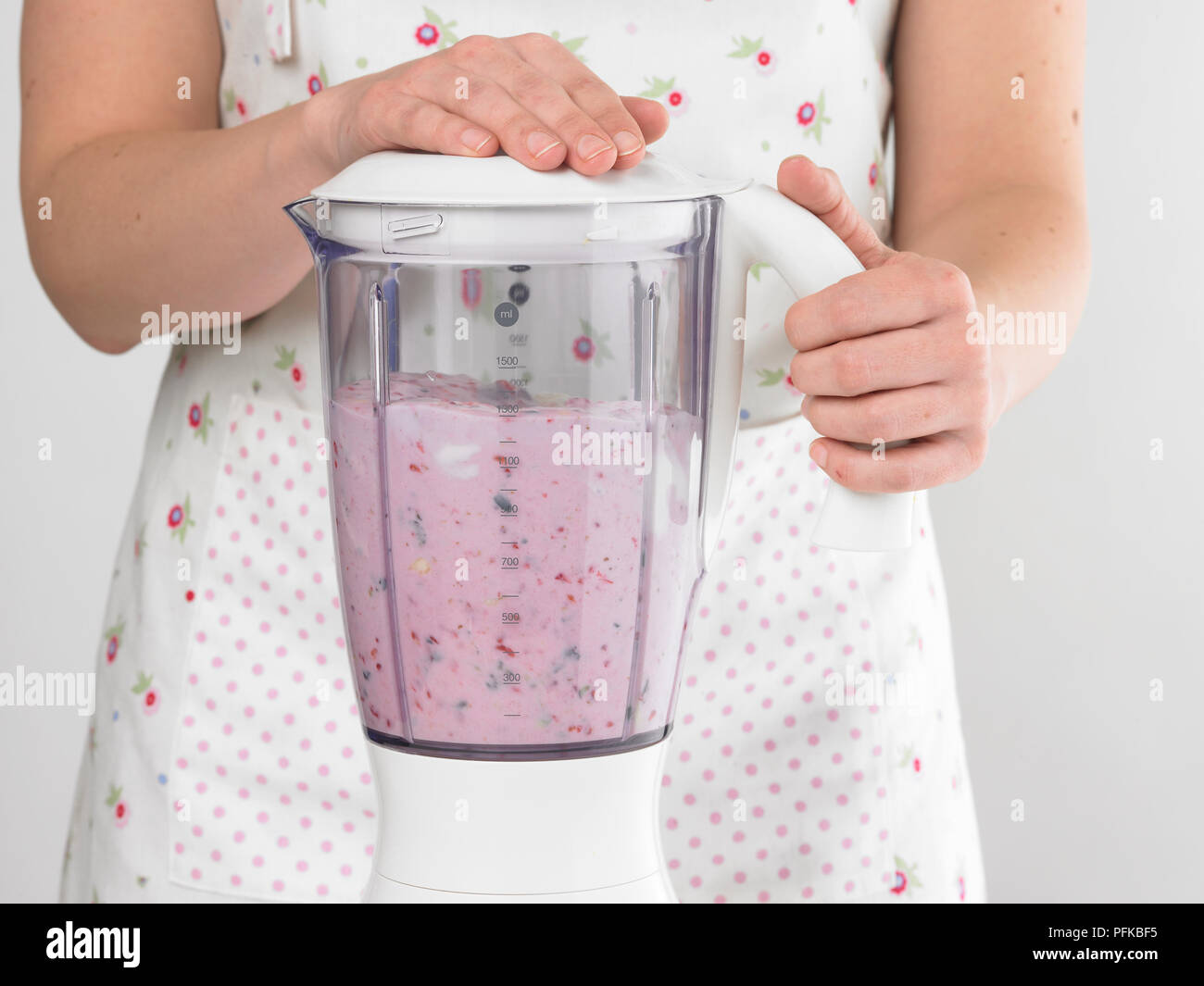 Young woman blending berries in blender Stock Photo - Alamy