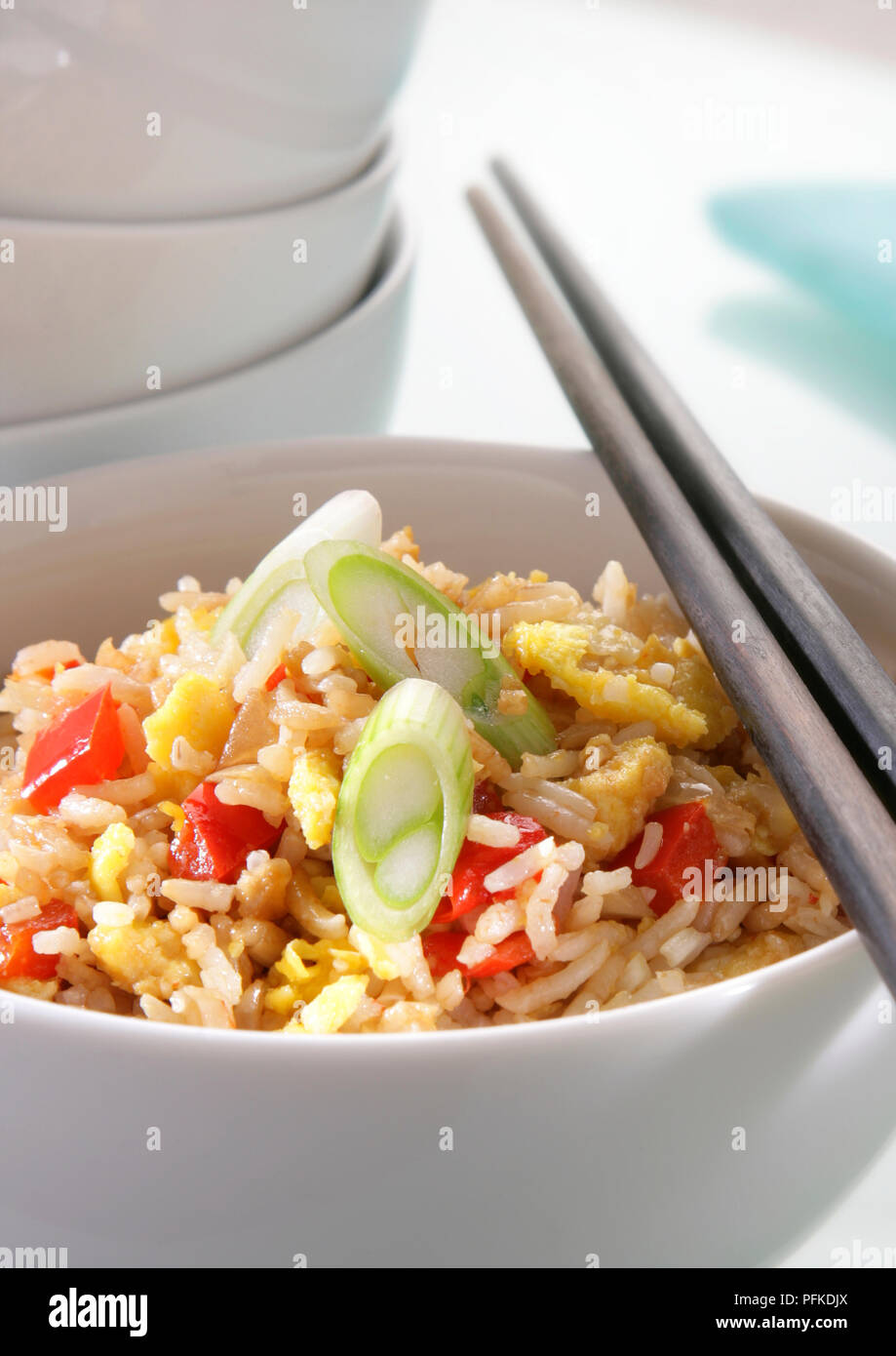 Bowl of egg-fried rice with red bell peppers and celery, with ...