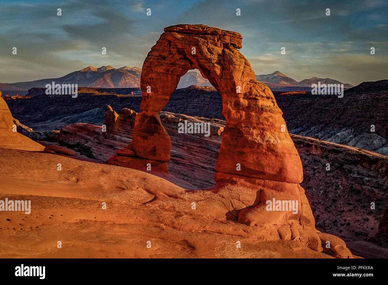 Delicate arch with sun and clouds at golden hour hi-res stock ...