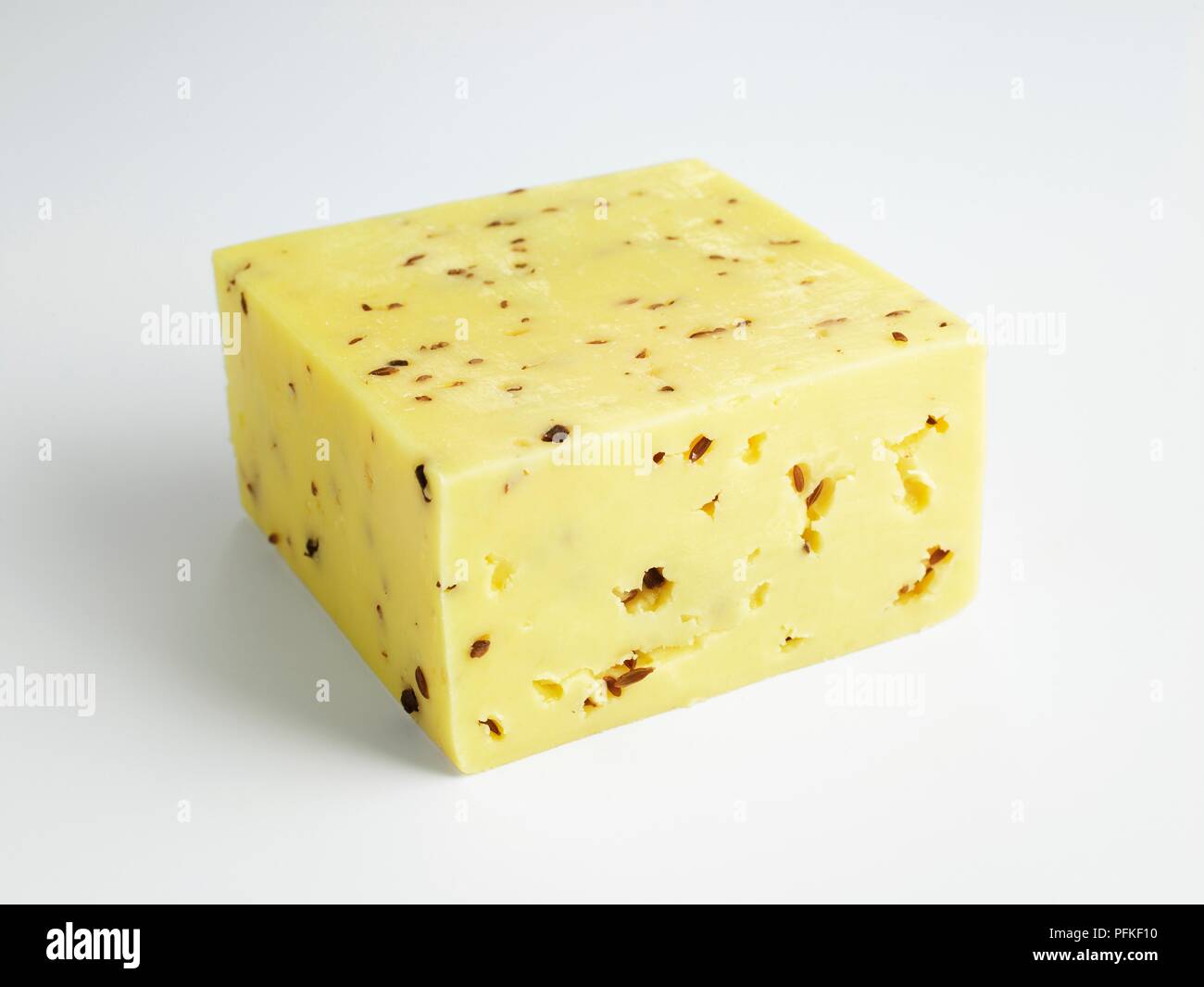 Block of Norwegian Nokkelost cow's milk cheese with cumin seeds and ...