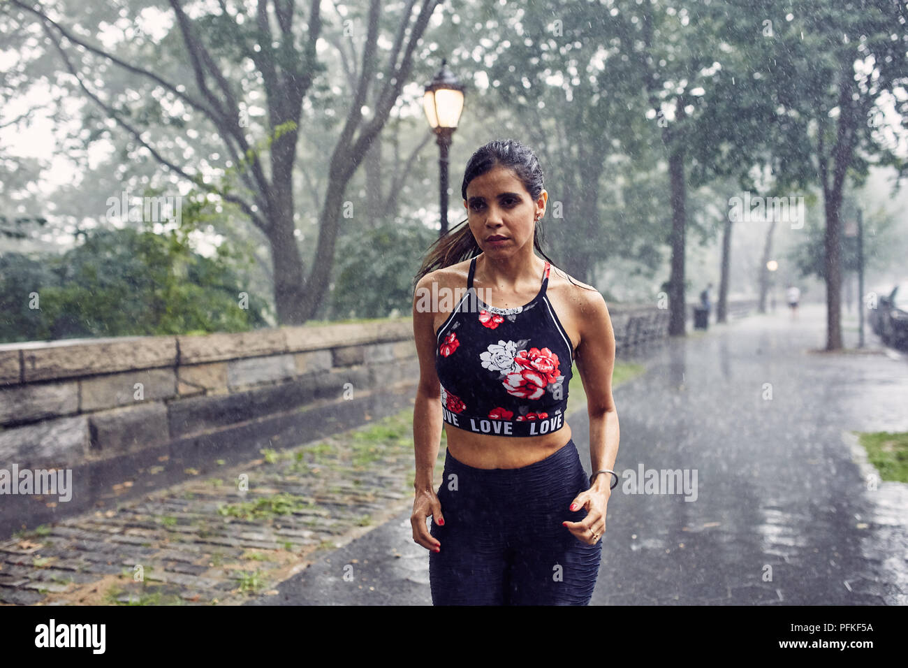 Hispanic Woman Running in the Rain Stock Photo - Alamy
