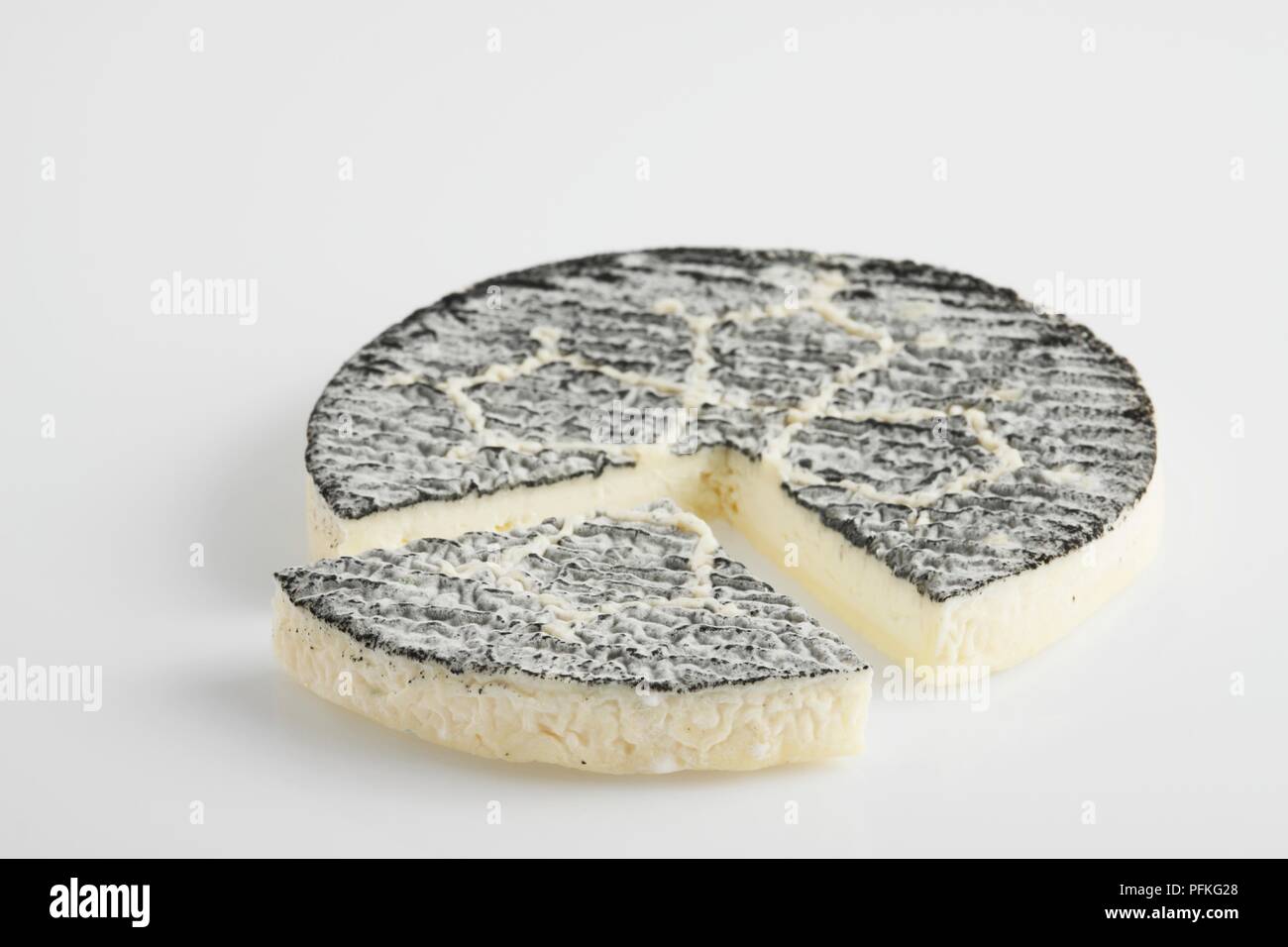 Flat disc and slice of French Cathare goat's cheese Stock Photo - Alamy