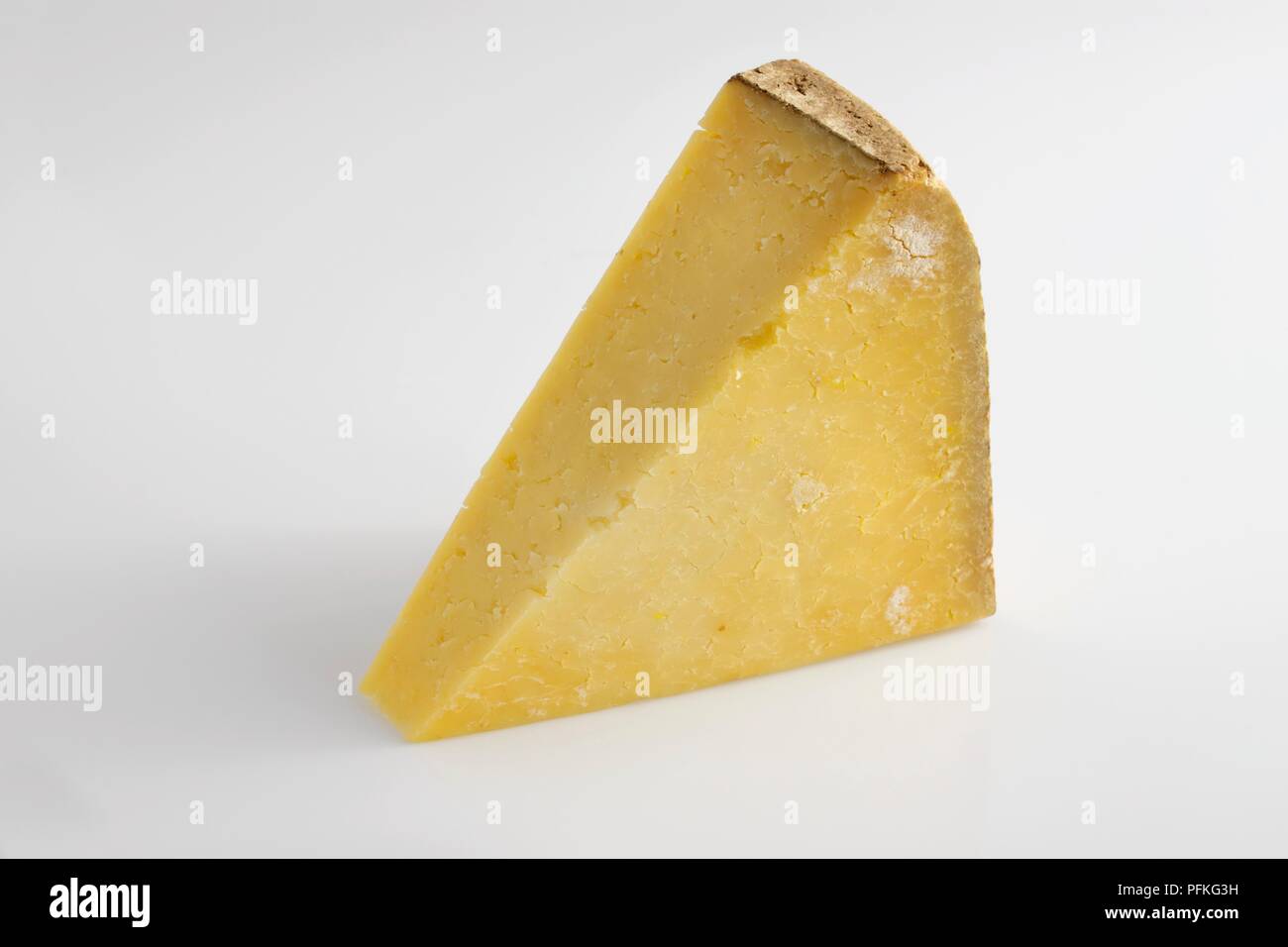 Slice of French Cantal AOC cow's milk cheese Stock Photo - Alamy
