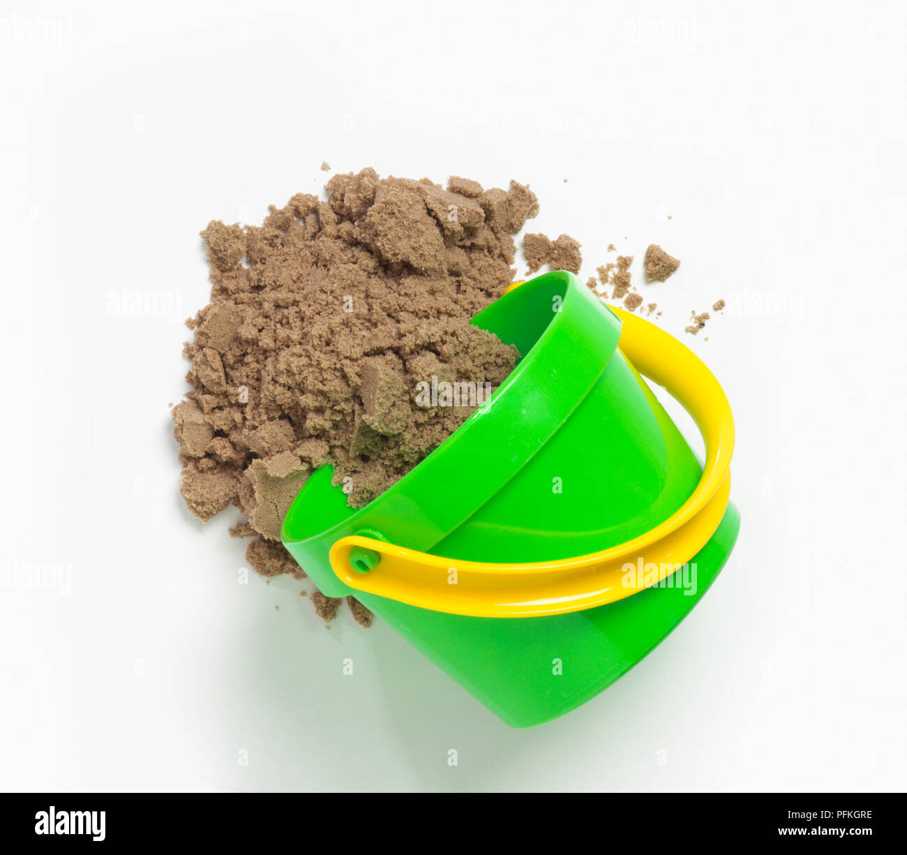 Sand spilling from colourful plastic green and yellow bucket Stock ...