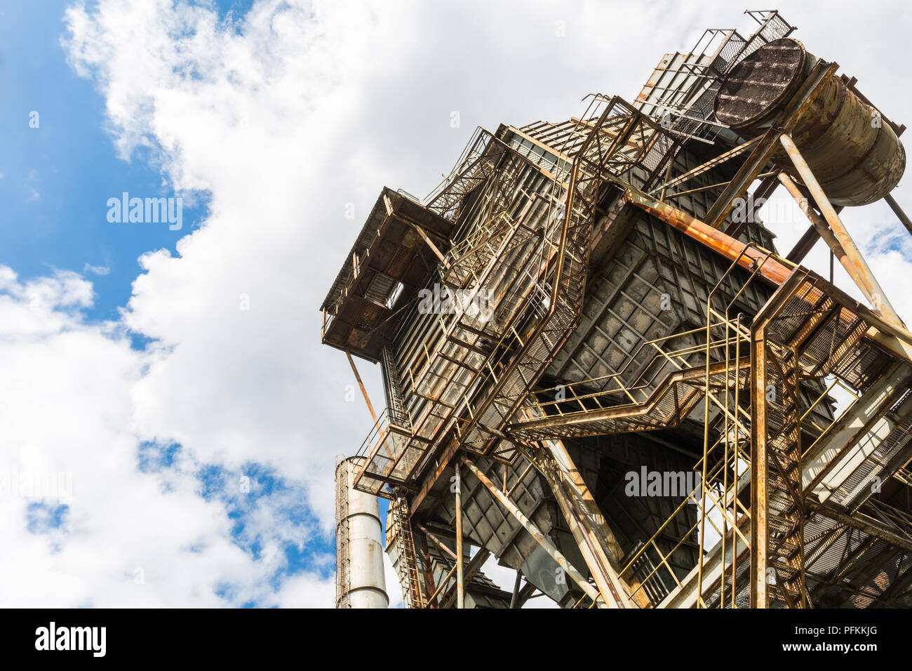 A tall, rusty factory tower of a lost industrial area from below Stock ...