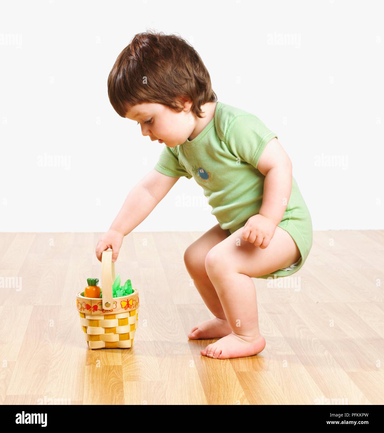 Baby boy picking up toy shopping bag Stock Photo - Alamy