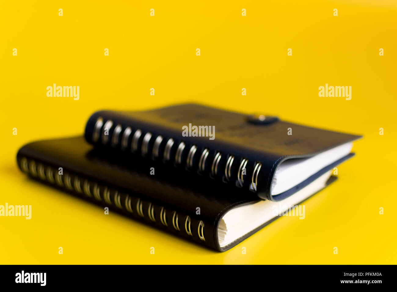 two notebook a side view of a side spring closeup yellow background ...