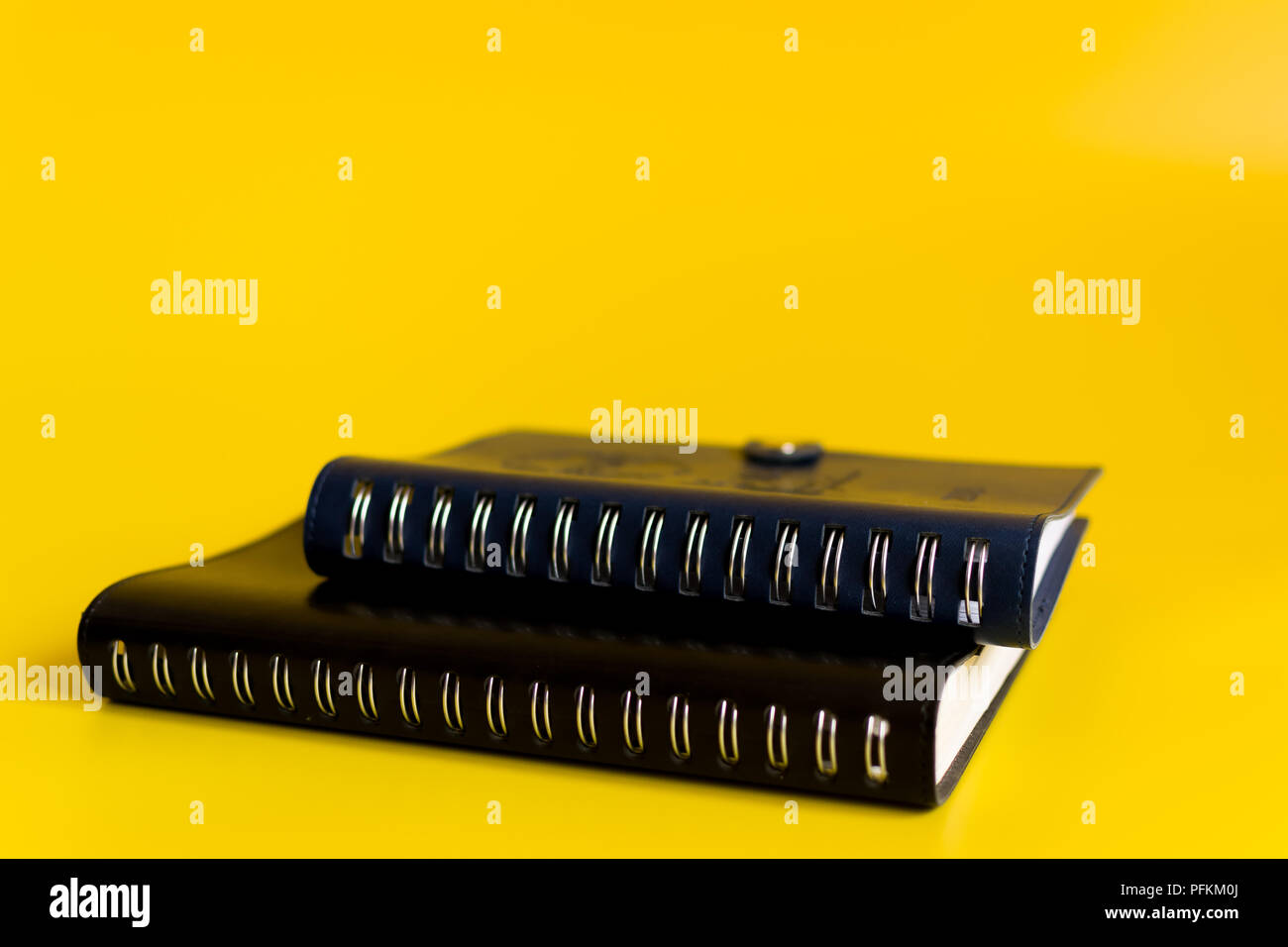 two notebook a side view of a side spring closeup yellow background ...