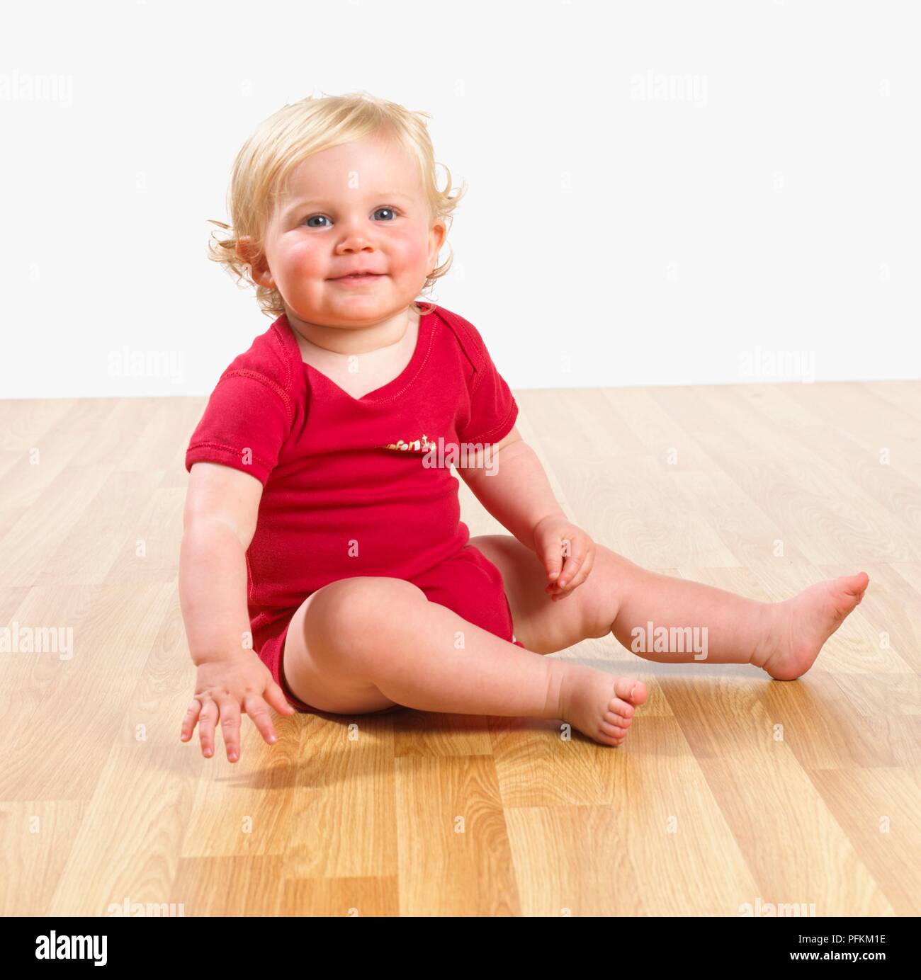Baby girl wearing red babygro Stock Photo - Alamy