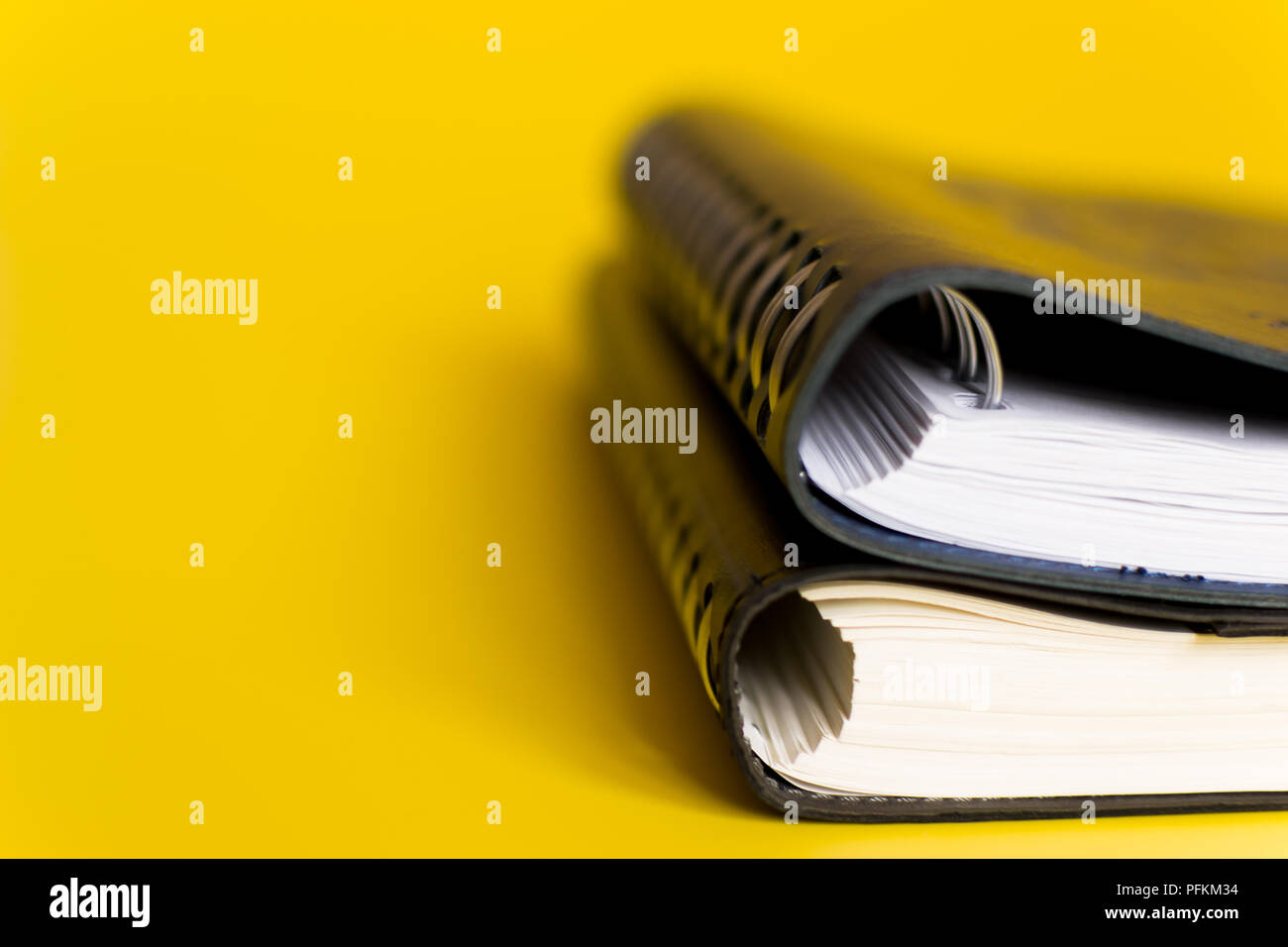 two notebook a side view of a side spring closeup yellow background ...