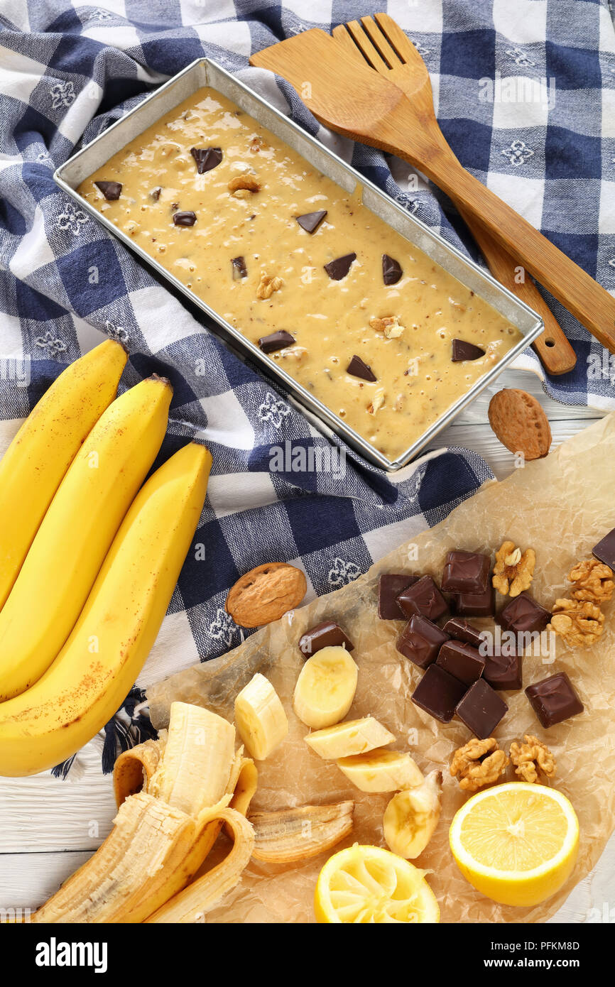 uncooked banana bread with walnuts and chocolate pieces in a loaf pan ...