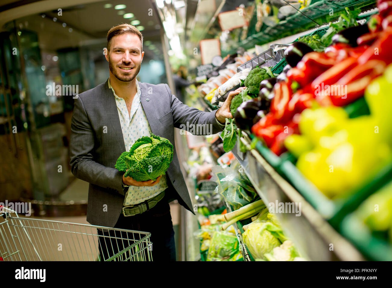 Young man buying vegetables in the supermarket Stock Photo - Alamy