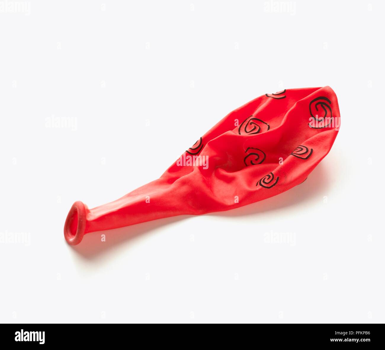 Red balloon with swirly pattern on, deflated Stock Photo - Alamy