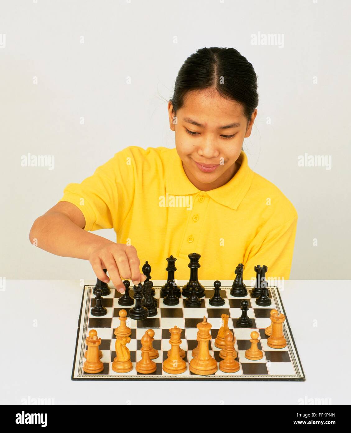Girl playing chess, front view Stock Photo - Alamy