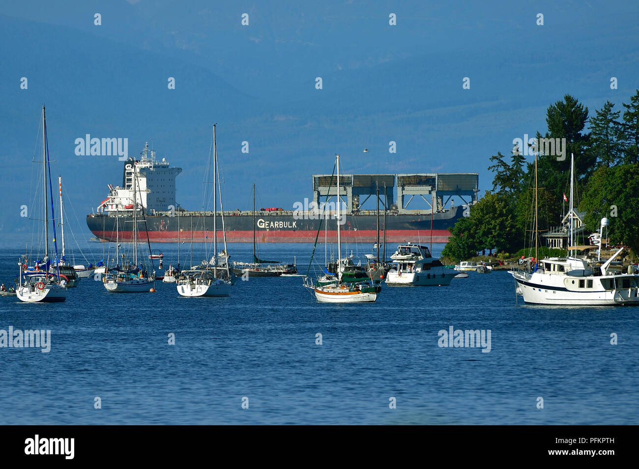 Sail boats , motor boats and a sea going container ship moored in the ...