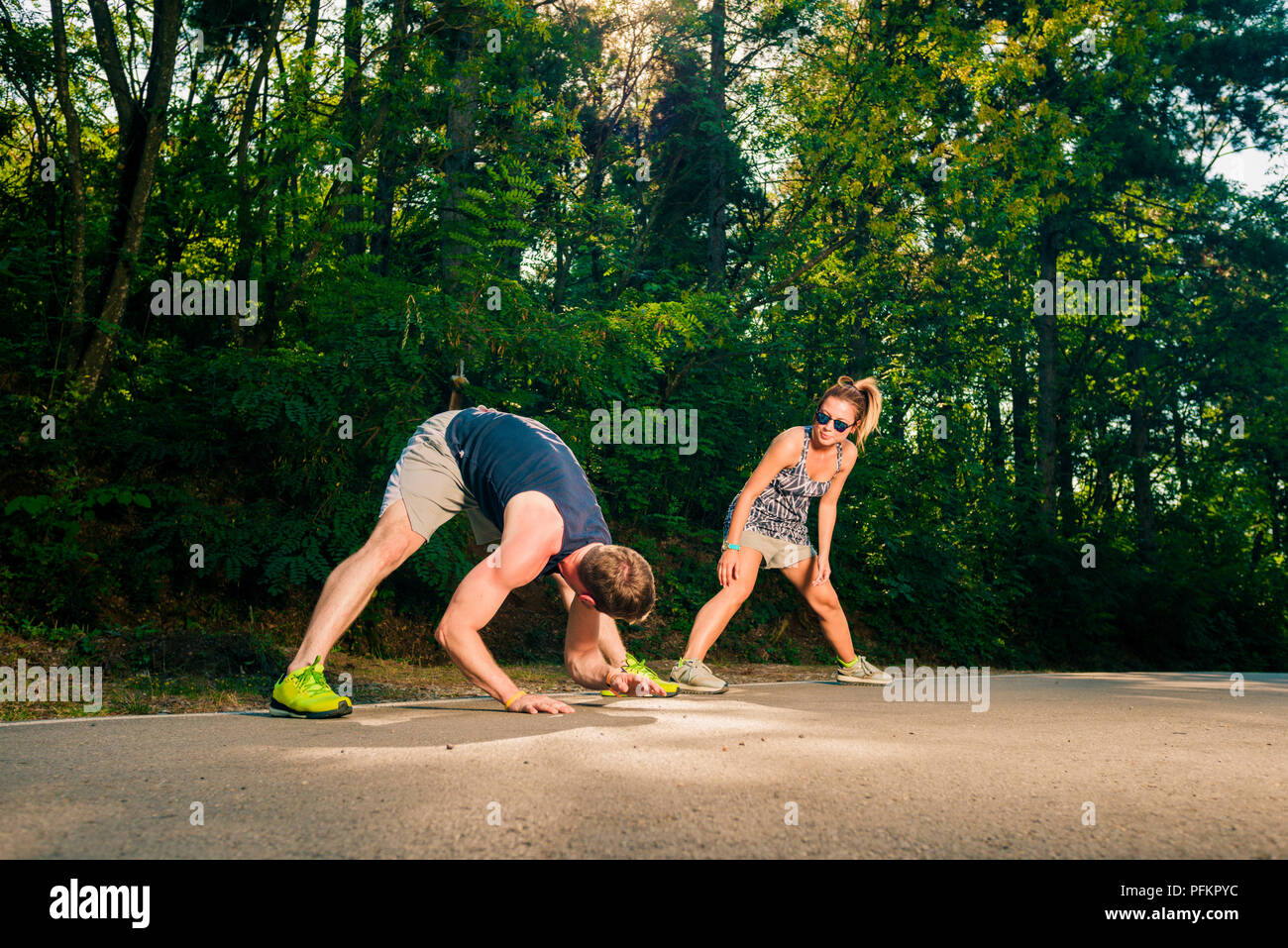 Athletic couple stretching out after running Stock Photo - Alamy