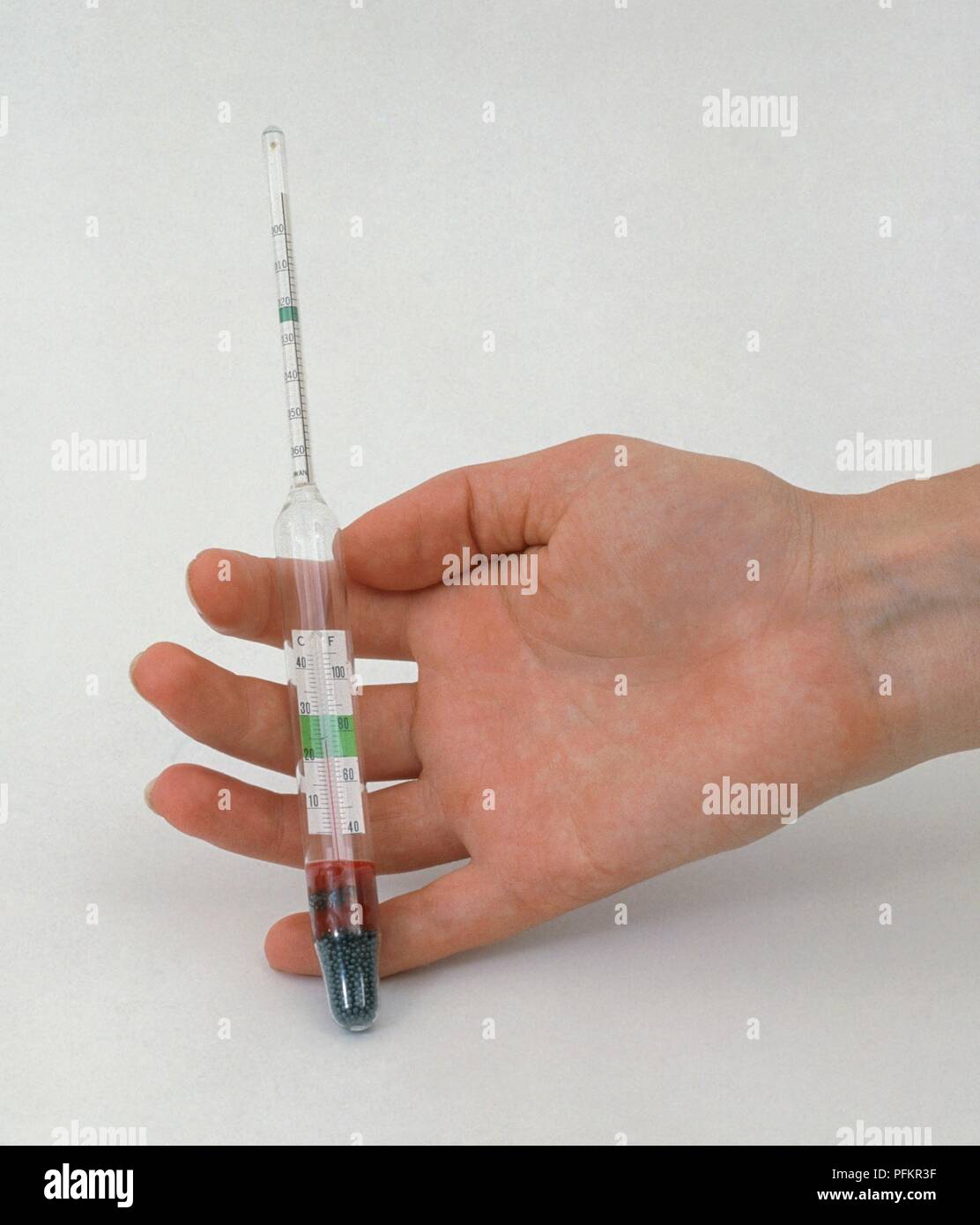 Hand holding a hydrometer Stock Photo - Alamy