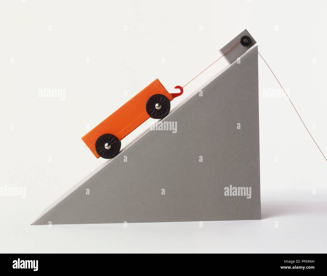 Red trolley pulled up slope by a pulley showing a reduced force needed ...