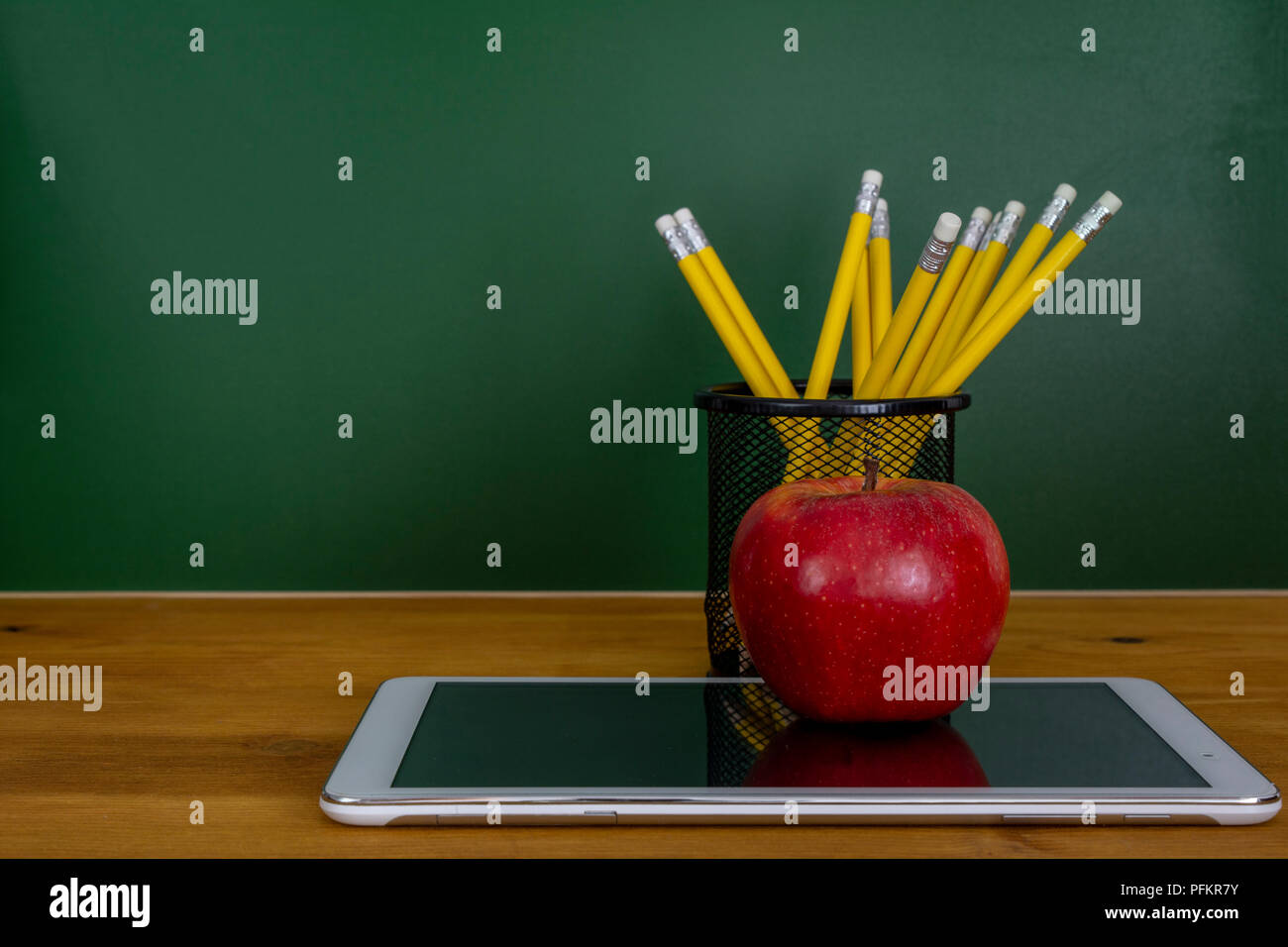 Back to school background with tablet, pencils and red apple over ...
