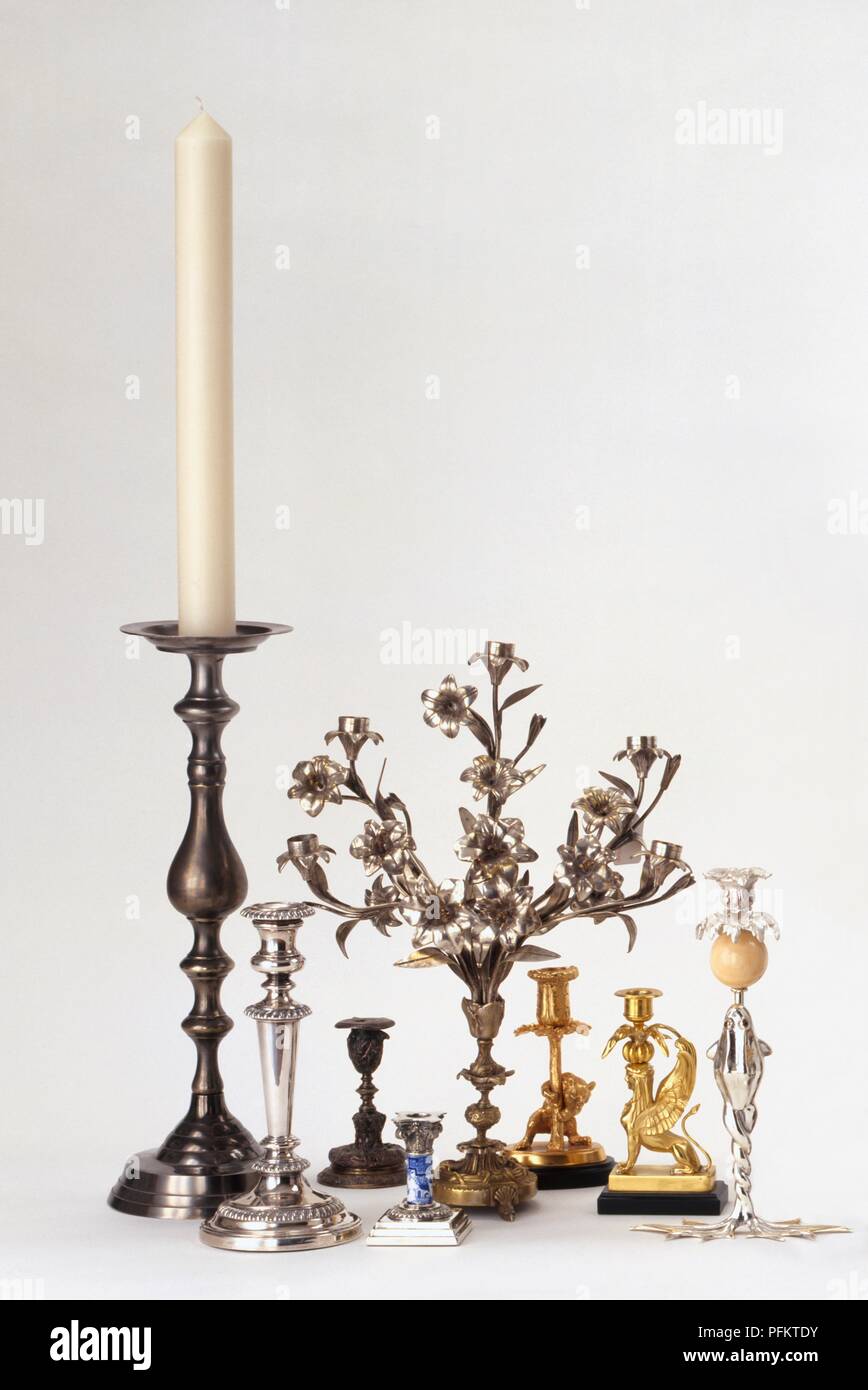 Long candle on tall lead candlestick and various smaller candlesticks ...