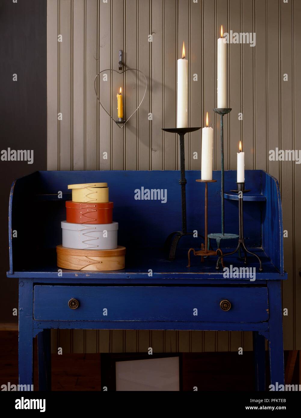 Candles and stack of boxes on old fashioned blue desk Stock Photo - Alamy