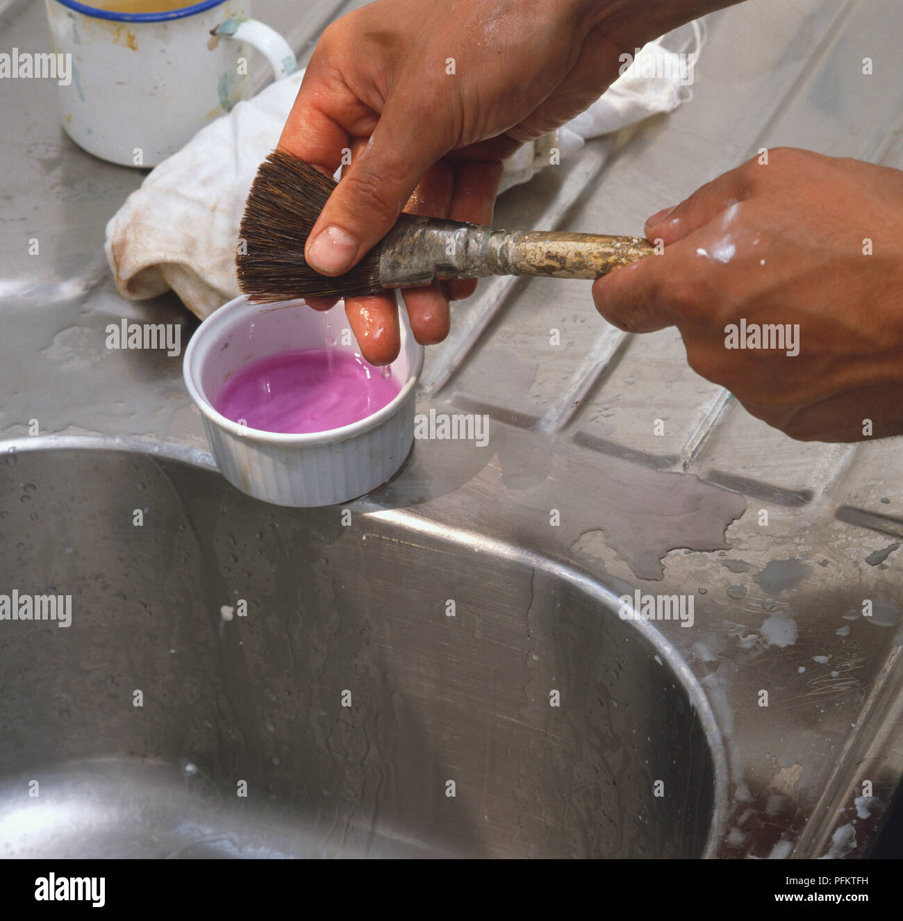 Using solvents to clean brush over kitchen sink Stock Photo - Alamy