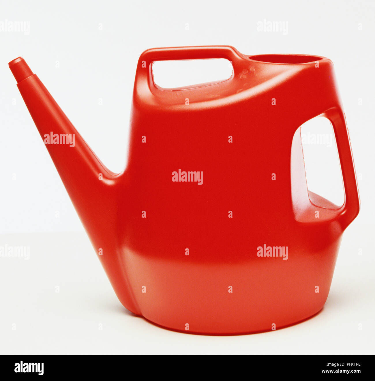 Red plastic watering can, side view Stock Photo - Alamy