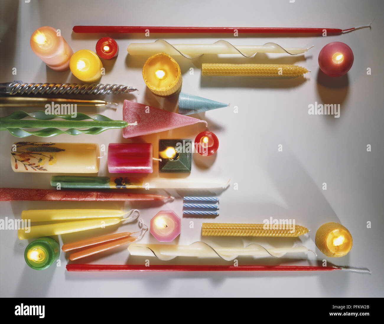 Selection of candles, lit and unlit, of different colours and shapes ...