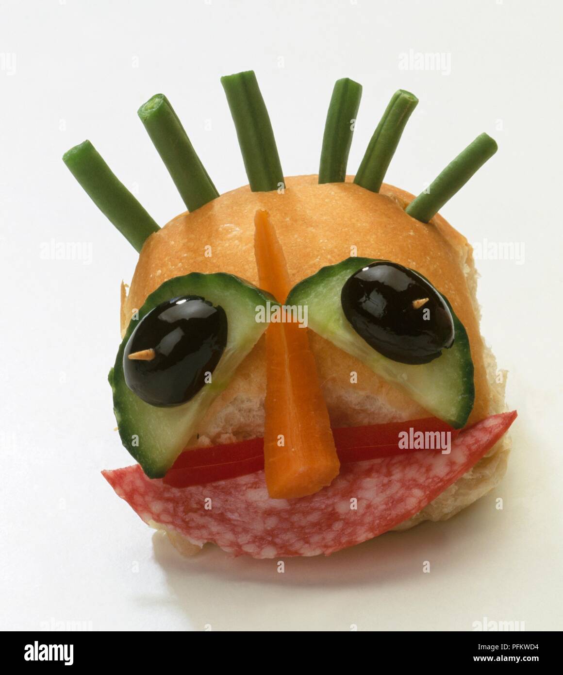 A bread roll made into a monster face with olives, cucumber and salami Stock Photo - Alamy